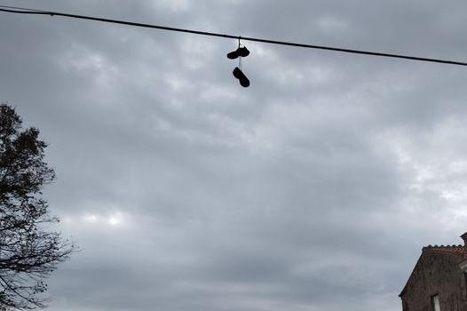 Tarquinia, scarpe appese al cavo elettrico a Sant’Antonio: la foto è virale